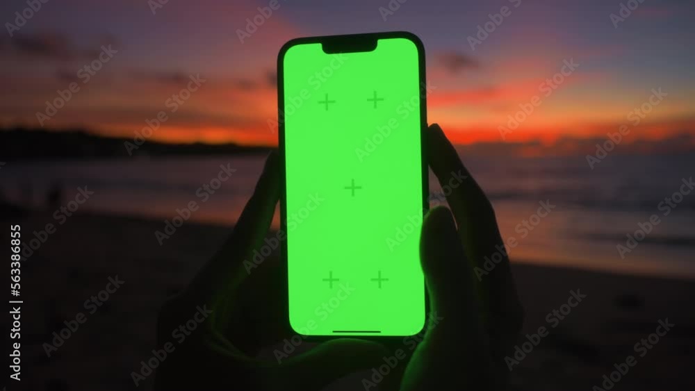 Silhouette person holds vertical mobile phone two hand and looking on ...