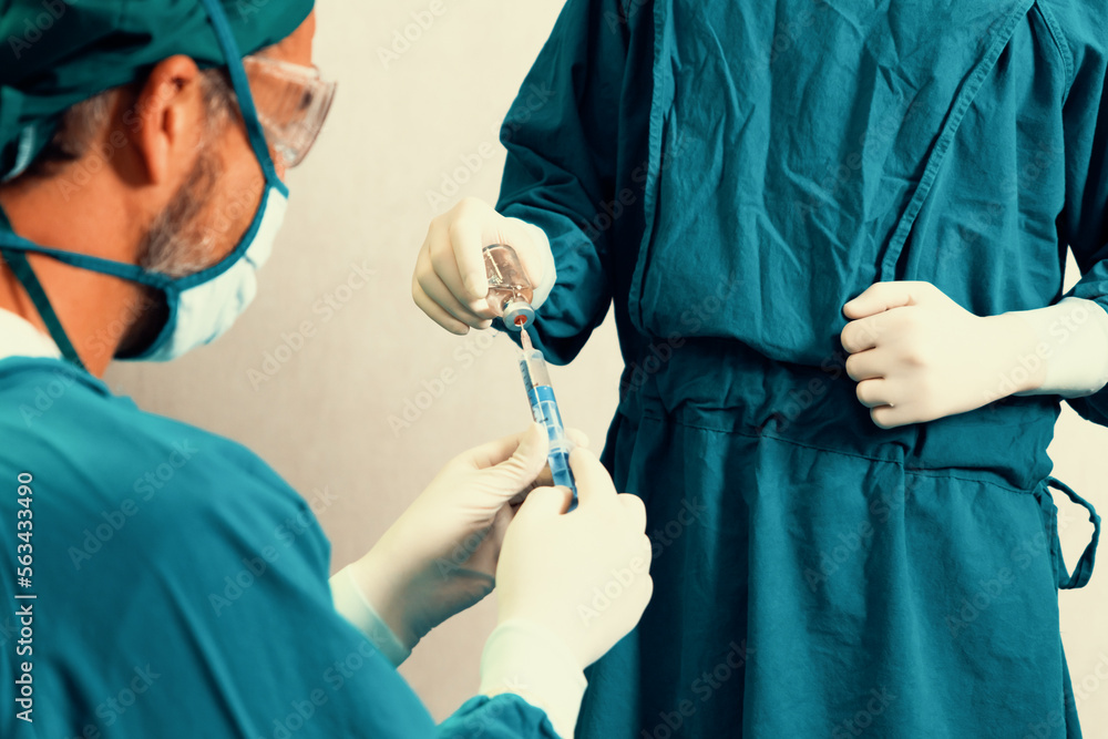 Surgeon fill syringe from medical vial for surgical procedure at ...