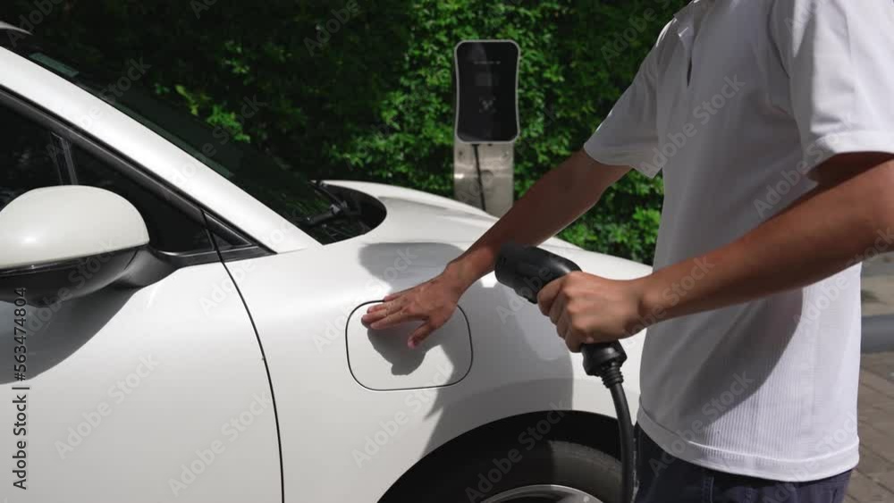 Progressive man install power cable plug to his electric vehicle, EV ...