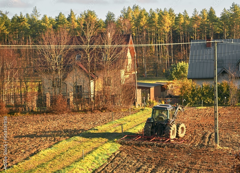 farm tractor on the soil field. busy rural area landscape. farmer ...