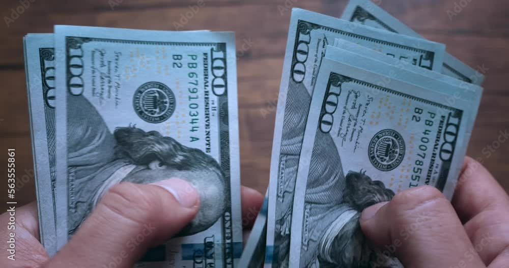 Close up male hands counting US Dollar bills or paying in cash. Male hands counting stack of ...