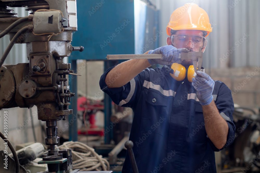 Young caucasian engineer man examining and measuring steel with ...