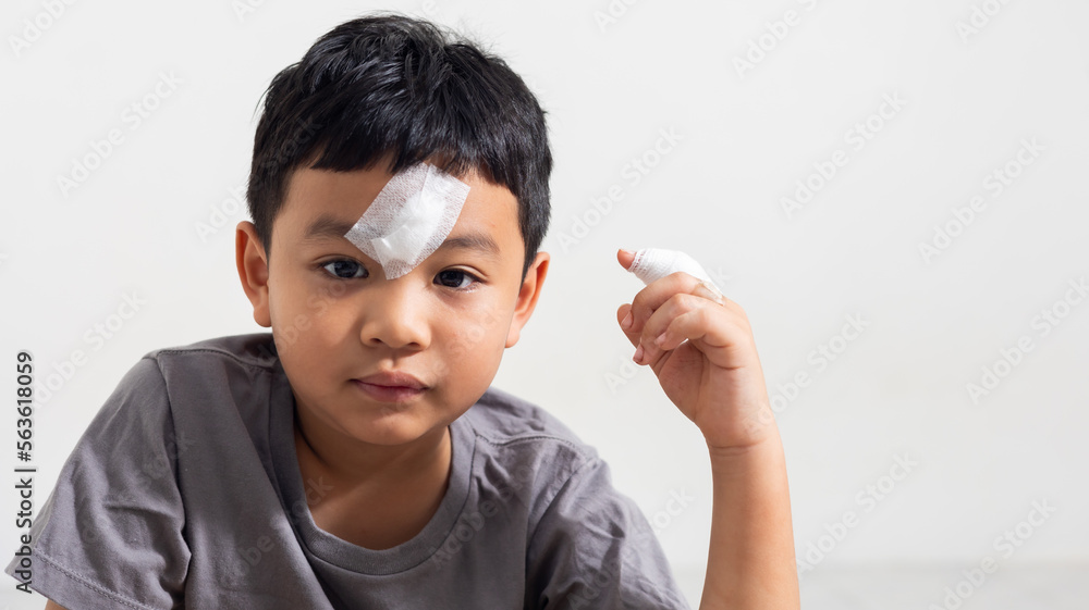 Asian boy is sad He had wound on face and fingers. Asian kid boy was ...