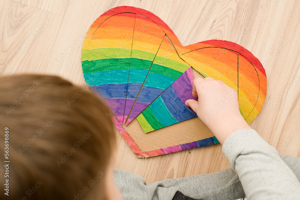 toddler inserting piece of heart shape rainbow puzzle. table game ... toddler inserting piece of heart shape rainbow puzzle. table game ...