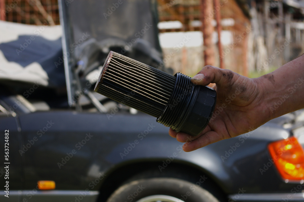 Dirty car oil filter held in a human hand. Used black oil filter ...