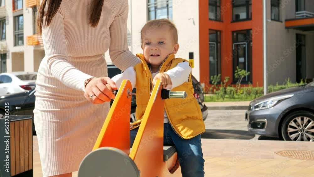Vidéo Stock Cute baby boy riding on the bouncy spring rider on the the ...