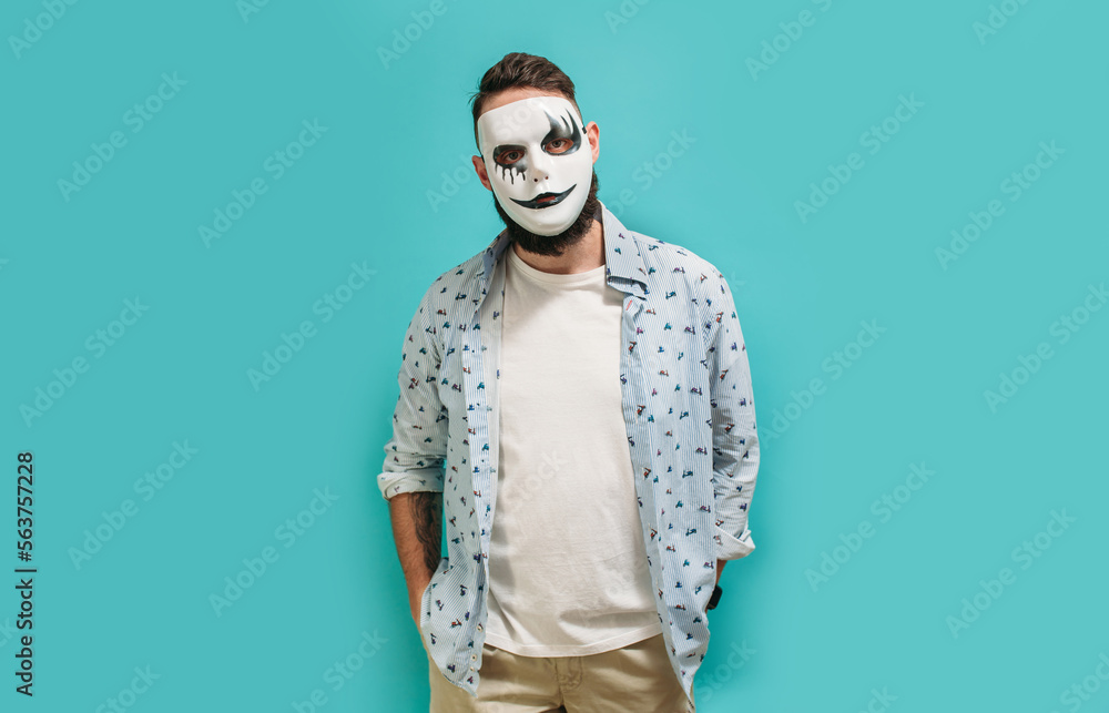 Portrait of a man with a beard covering his face with a white mask ...