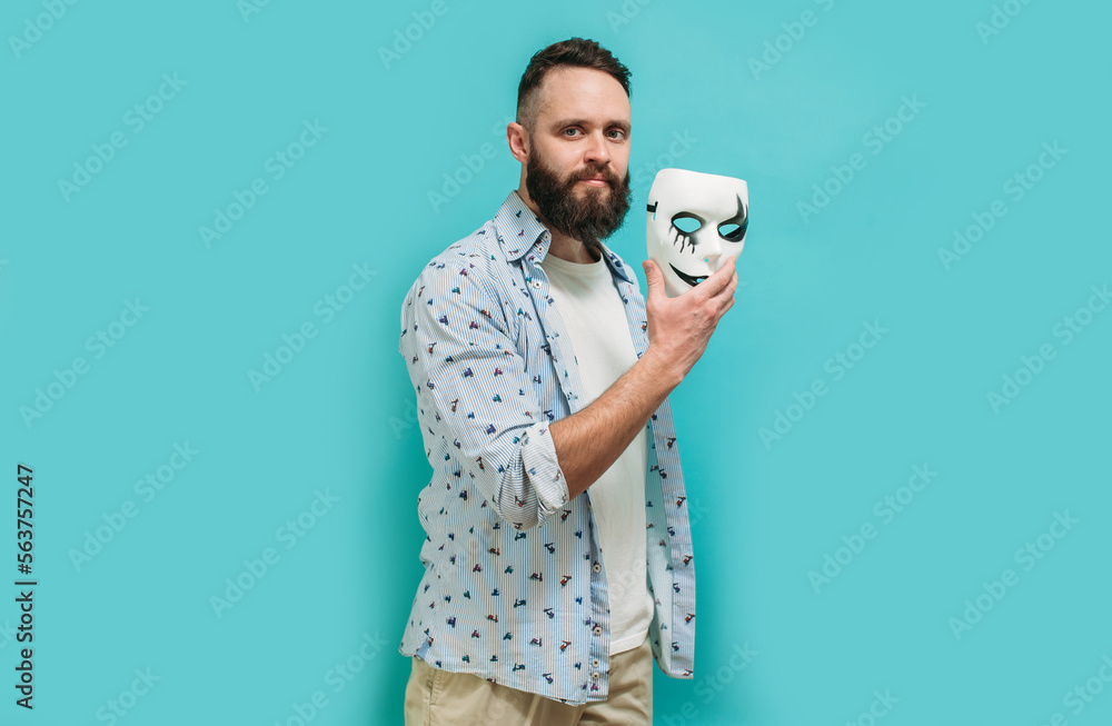 Portrait of a man with a beard covering his face with a white mask ...