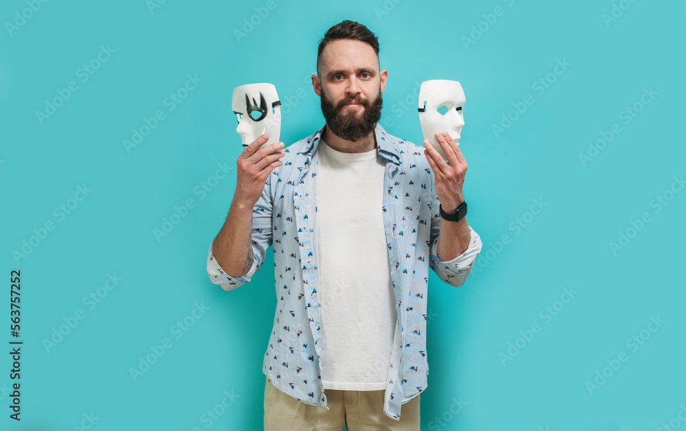 Portrait of a man with a beard covering his face with a white mask ...