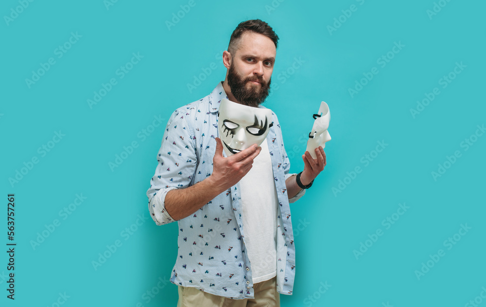 Portrait of a man with a beard covering his face with a white mask ...
