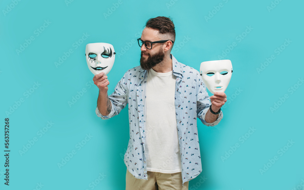 Portrait of a man with a beard covering his face with a white mask ...