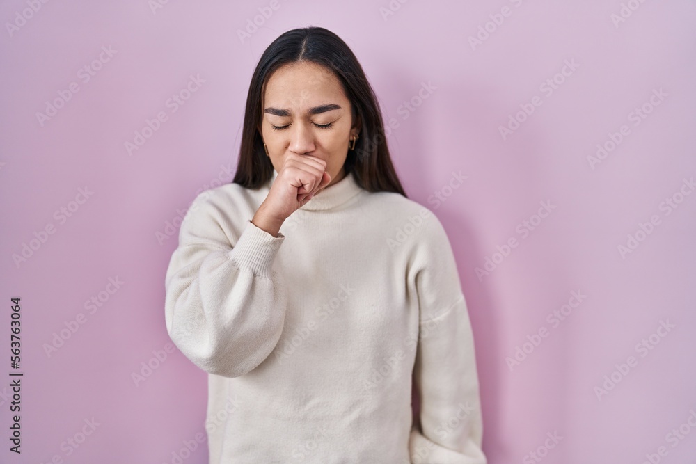 Young south asian woman standing over pink background feeling unwell ...