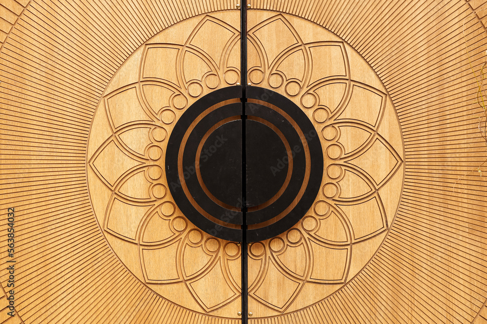 Abstract sun circles and shapes sculpture on a big wooden door. Wood ...
