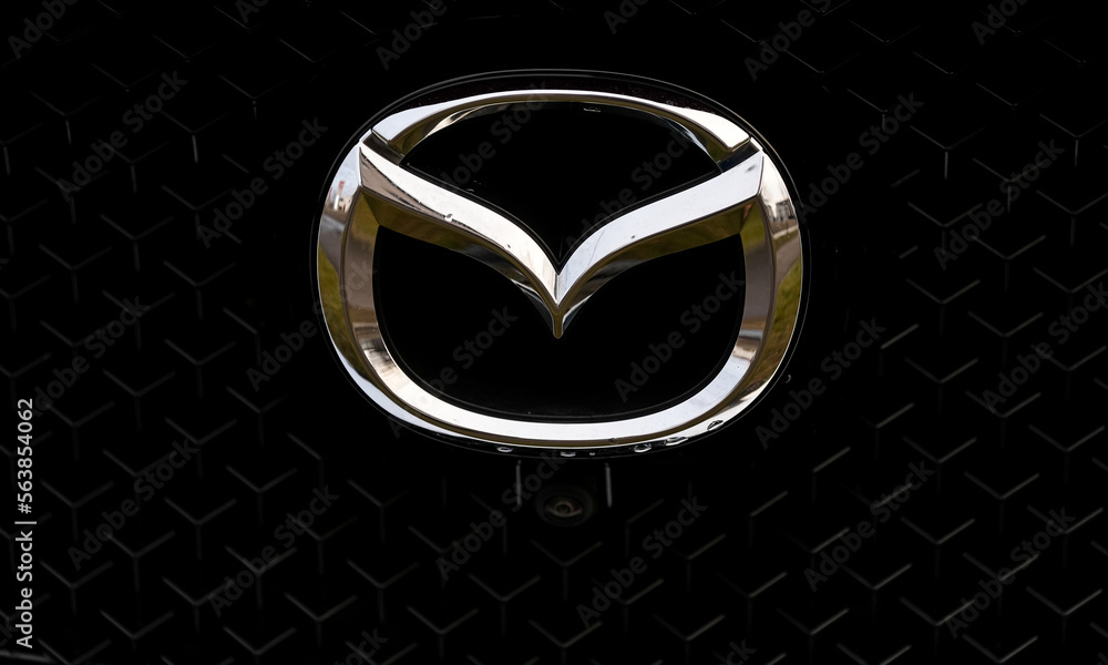 The logo sign of Mazda Japanese car company against dark background in ...