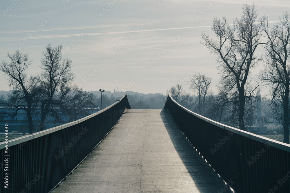 An empty pedestrian bridge in the early morning in cold weather. A ...