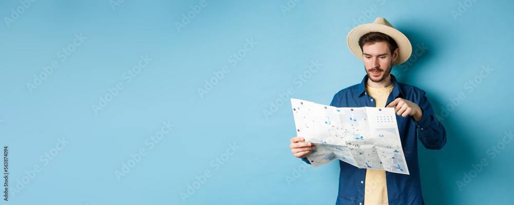 Handsome guy choosing place to go, pointing at sighseeing map on ...