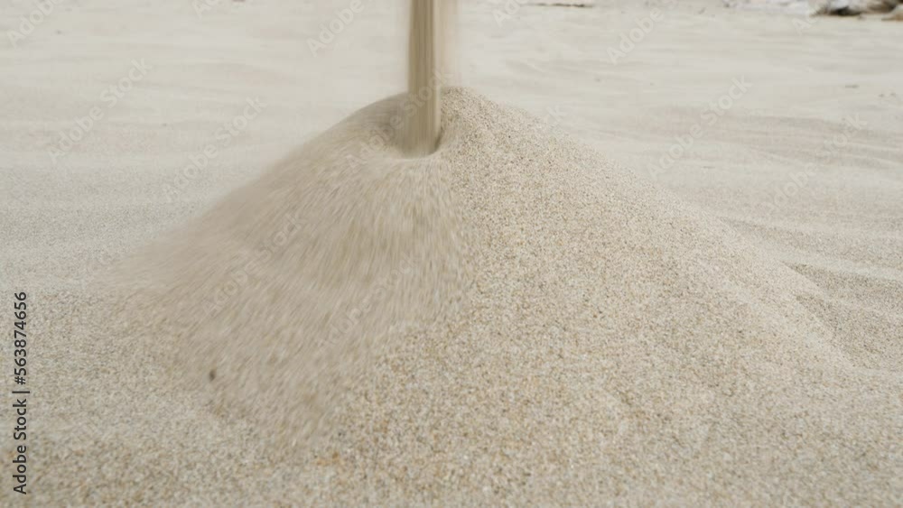 Sand falling onto pile on beach. Falling sand forms a pile Stock ビデオ | Adobe Stock