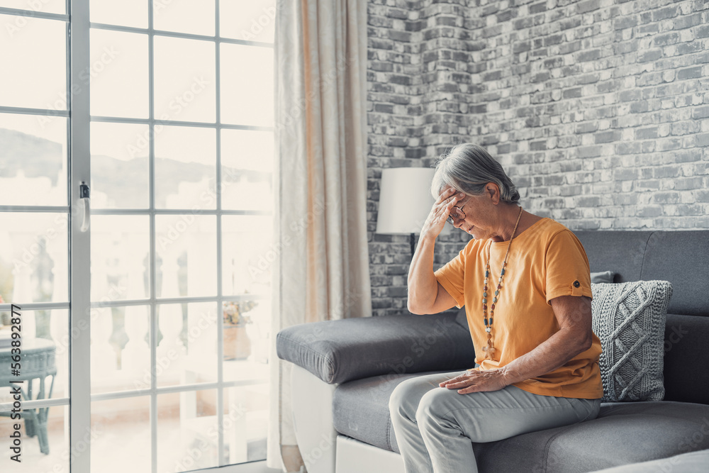 Sad depressed middle aged mature woman sitting alone at home touching ...