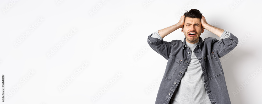 Frustrated guy crying and panicking, holding hands on head and ...