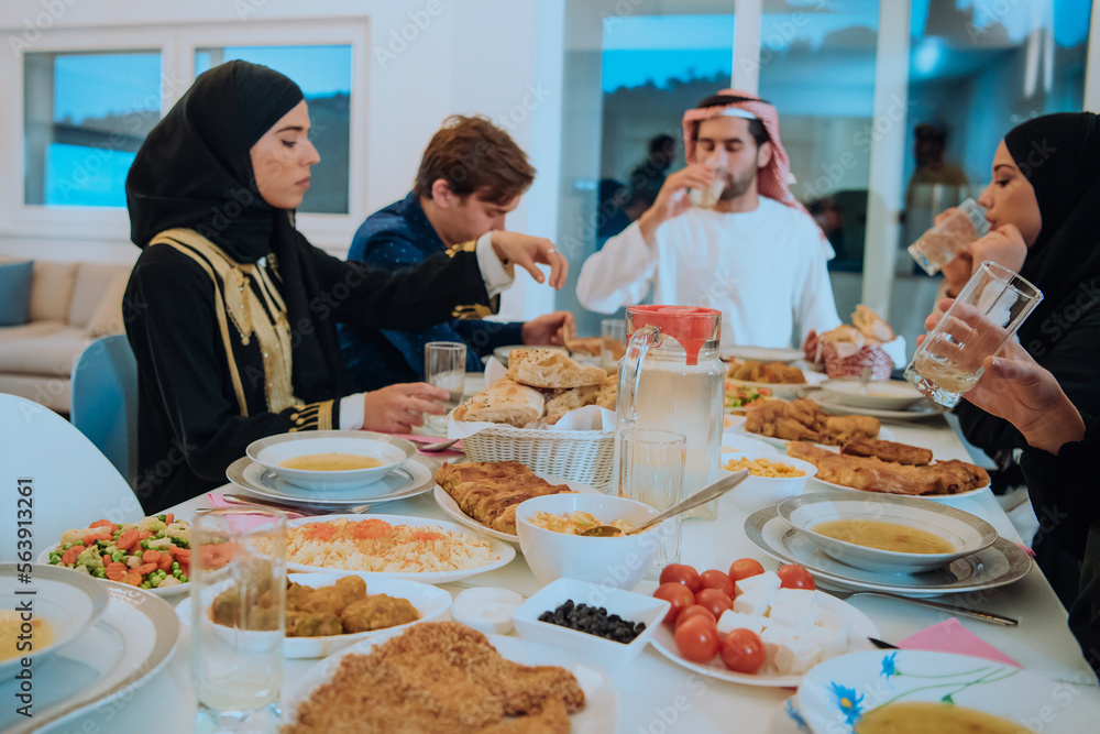 Muslim family having Iftar dinner drinking water to break feast. Eating ...