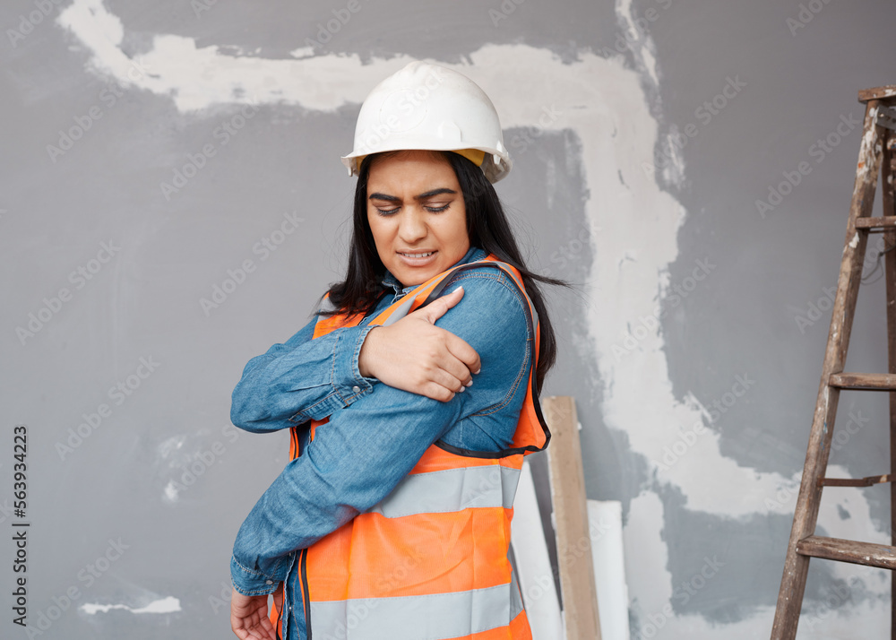 Construction worker holds shoulder in pain from workplace injury on ...