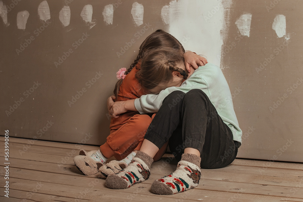 two little sister girls hugged and crying in the attic of the house ...