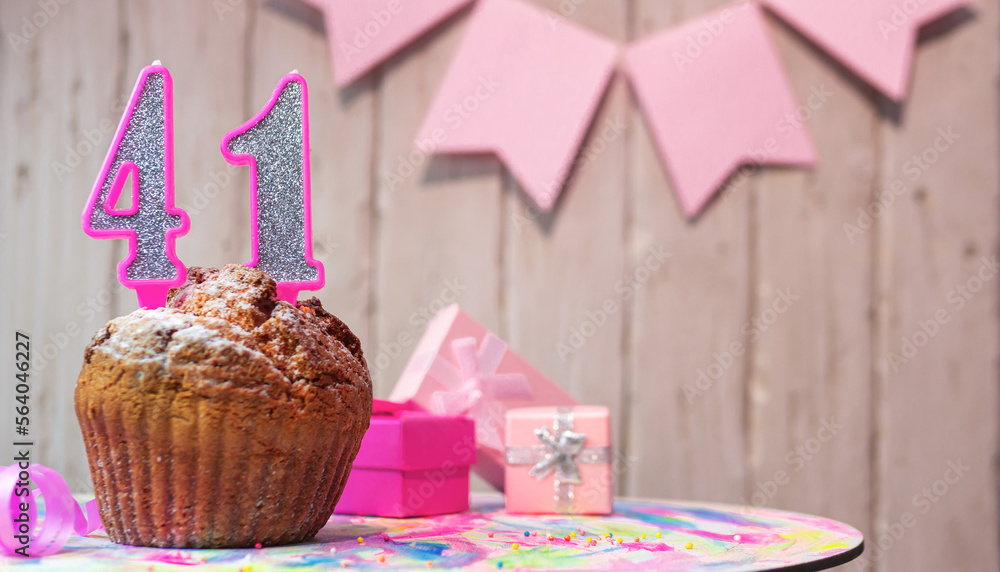 Festive cake or muffin with a pink candle with a number 41. Happy ...