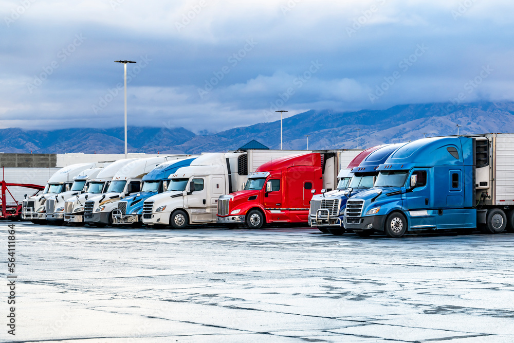 Professional industrial grade big rigs semi trucks standing in row on ...