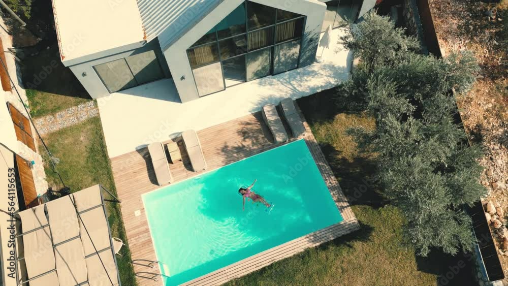Aerial view of luxury pool villa and woman swimming at the pool. Stock ...