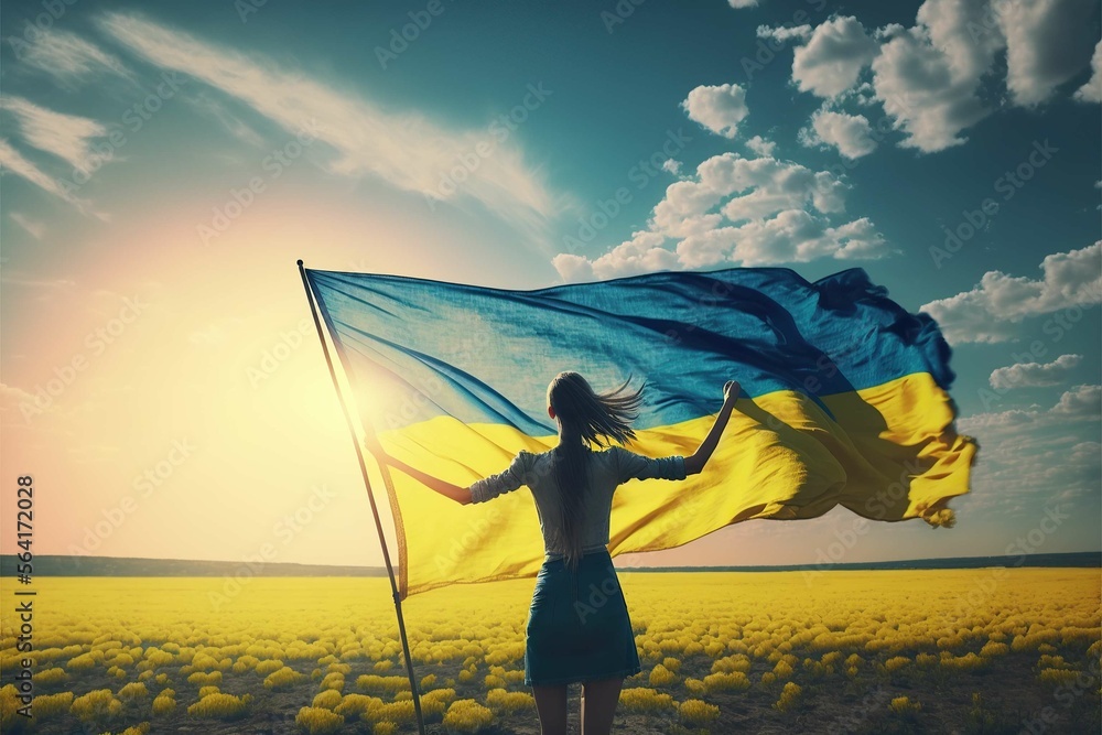 Ukrainian patriot woman waving national flag in canola yellow field ...