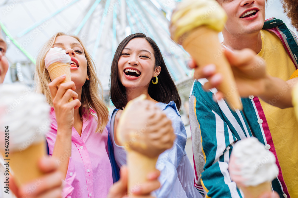 Multiracial young people together meeting at amusement park and eating ...