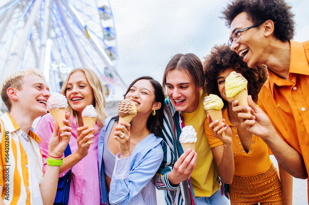 Multiracial young people together meeting at amusement park and eating ...