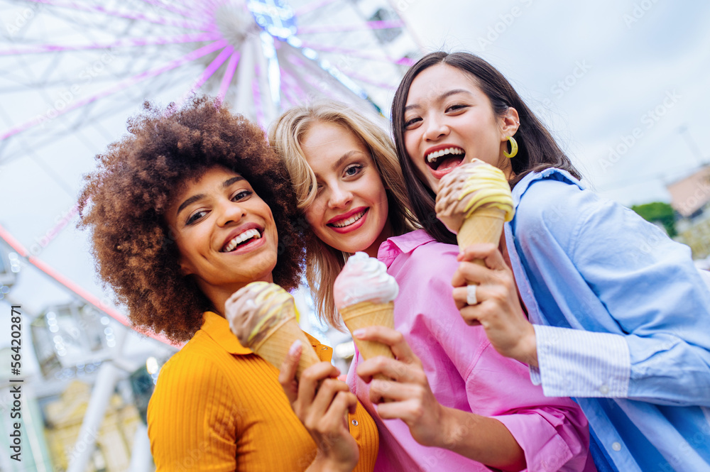 Multiracial young people together meeting at amusement park and eating ...