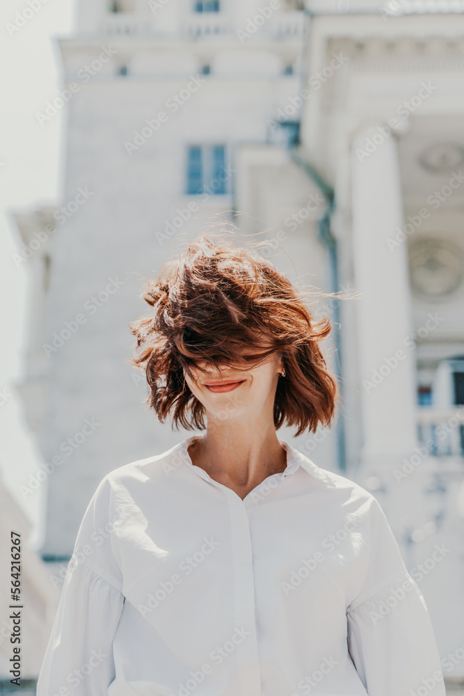 Wind hair style. A portrait of a woman outdoors, her shoulder-length ...