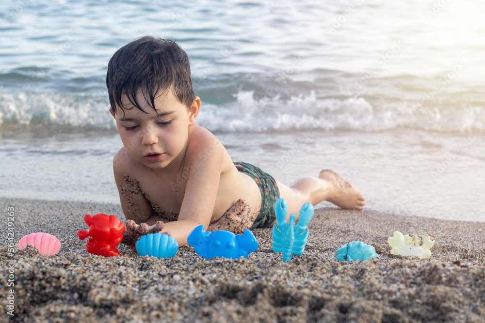 kid playing on beach sand running digging using plastic toys crab ...