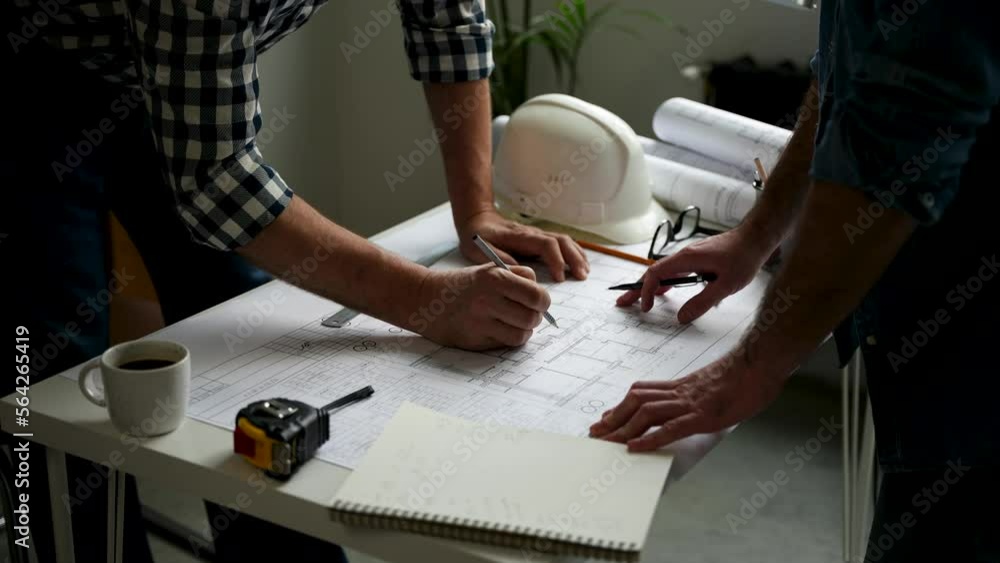 Two cropped architects discussing floor plan at table in office. Design ...