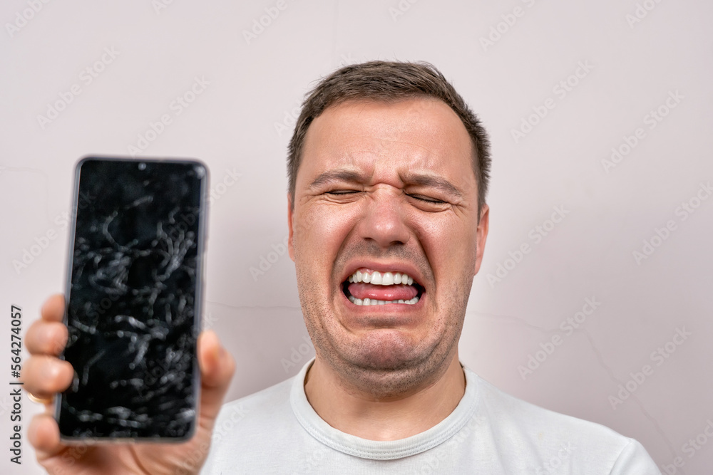 Terrified male with damaged phone. Worried sad man accidentally ...