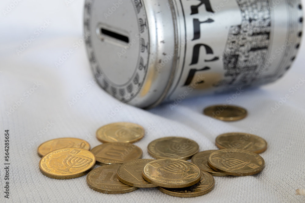 Money and coins. a charity box with coins. [Tzedakah] is a Hebrew word ...