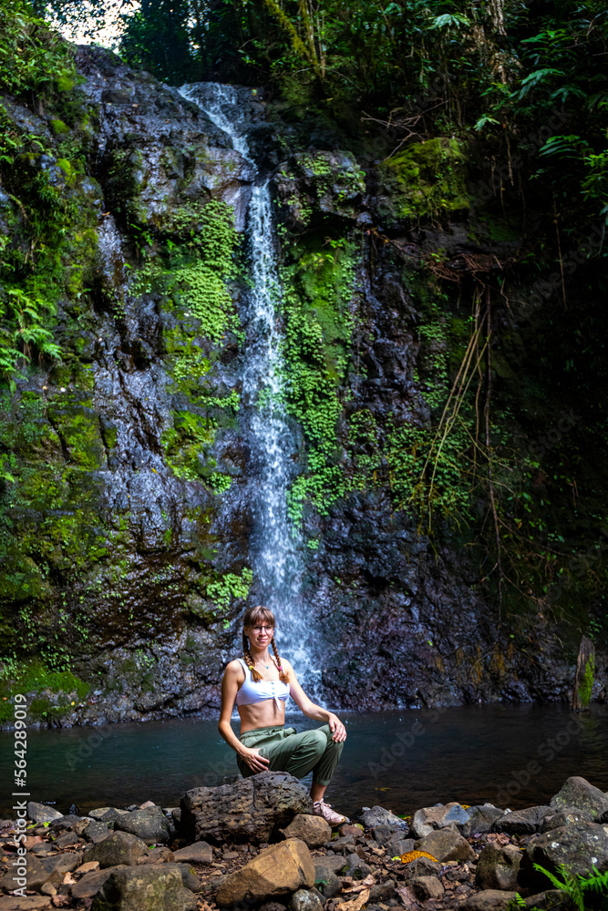 beautiful girl in bikini sitting by large waterfall in australian ...