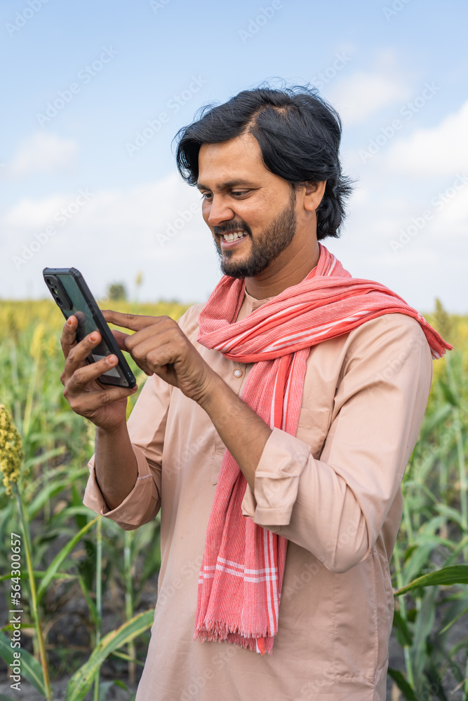 vertical shot of farmer busy using mobile phone at agricultural farm ...