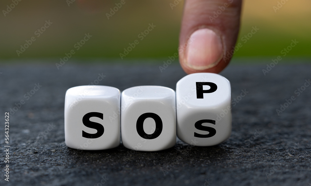 Foto de Hand turns dice and changes the abbreviation SOS (save our ...