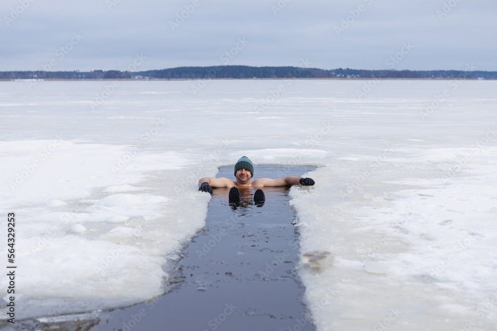 Foto de Winter swimming. Woman in frozen lake ice hole. Swimmers ...