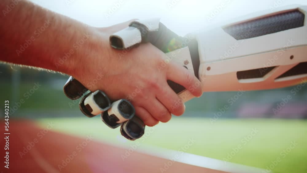Man and robot shaking hands at stadium. Blurred background. Sport ...