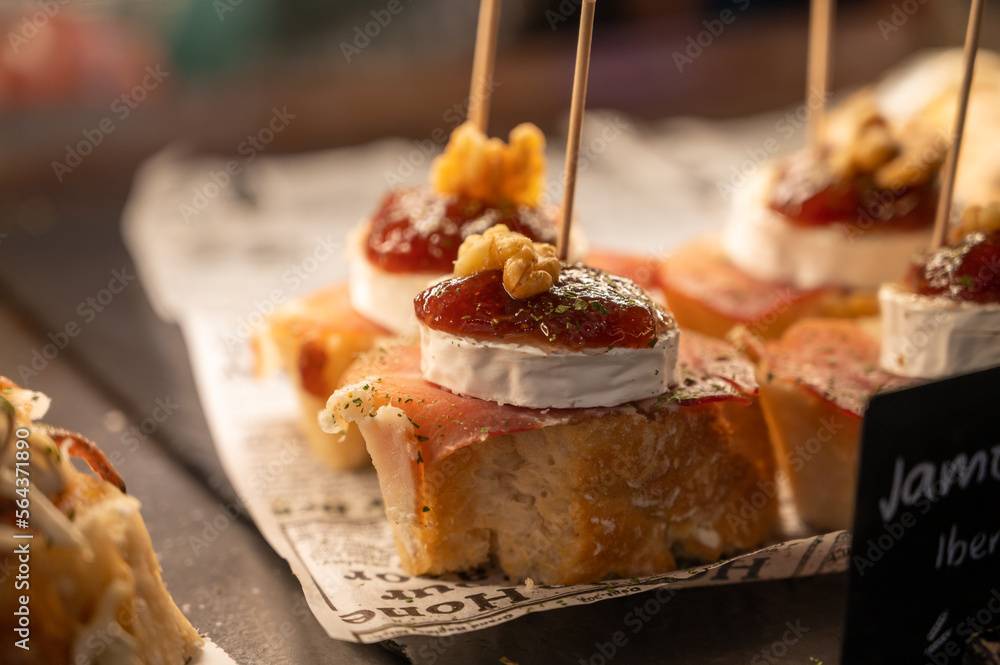 Typical snack of Basque Country, pinchos or pinxtos skewers with small ...
