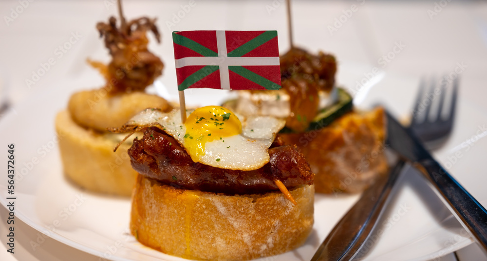 White board with typical snack and flag of Basque Country, pinchos or ...