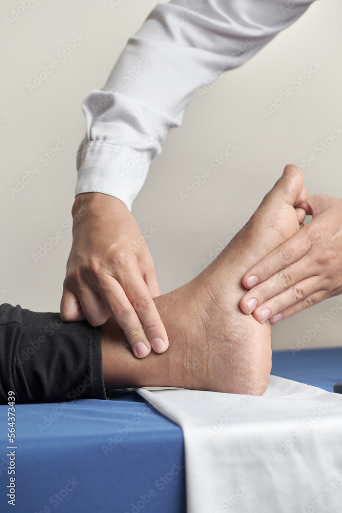 nurse's hand palpating posterior tibial pulse on upright patient's foot ...