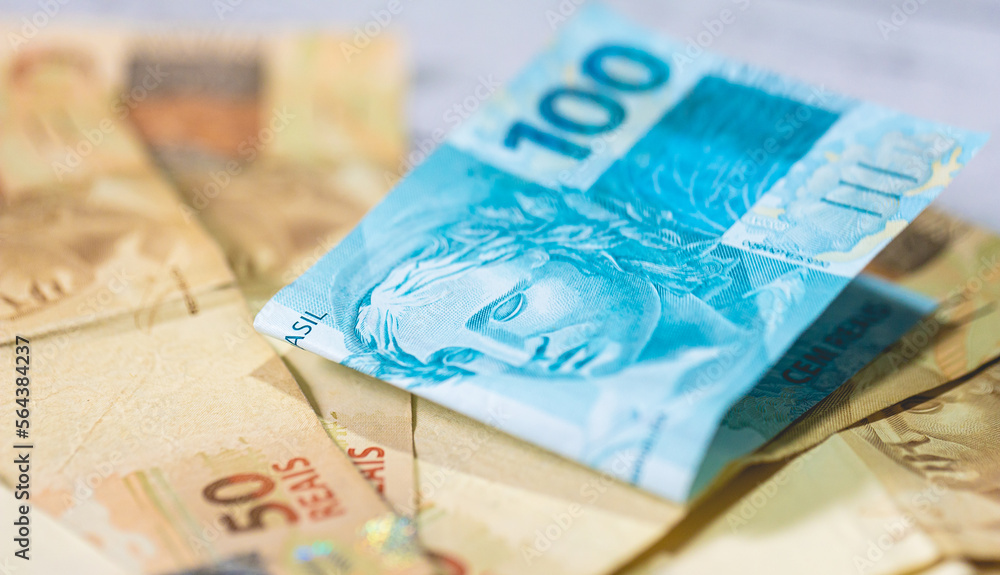 Notas do Real Brasileiro sobre uma mesa de madeira. Economia brasileira ...