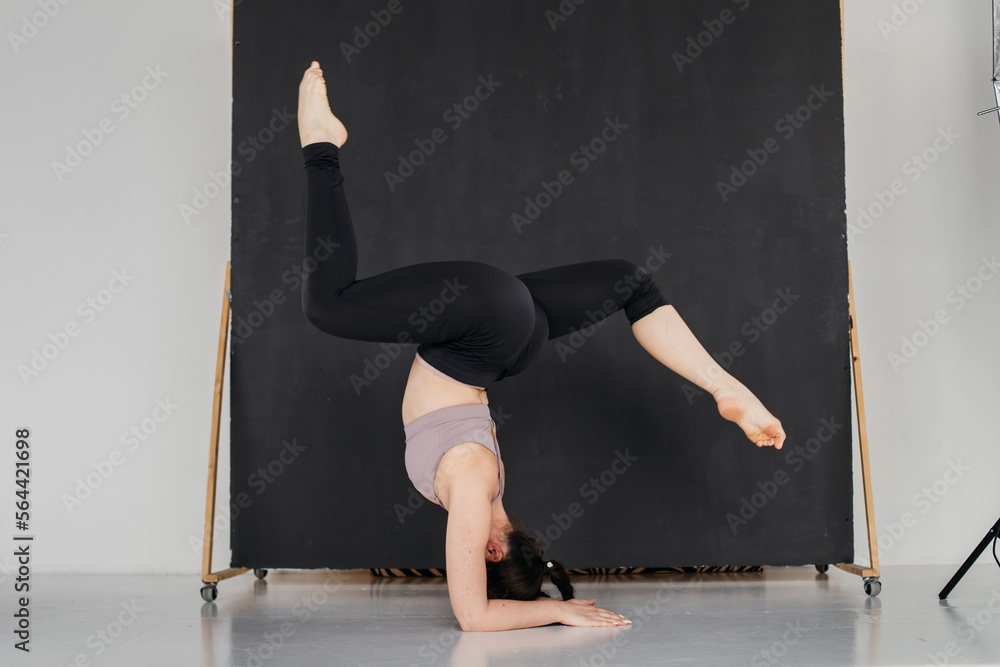 Young professional gymnast woman standing on splits. Pretty brunette ...