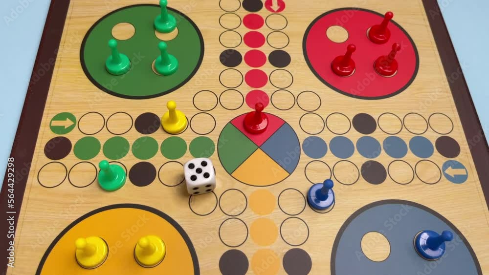 People play Ludo or Pachisi board game on beautiful wooden play board ...