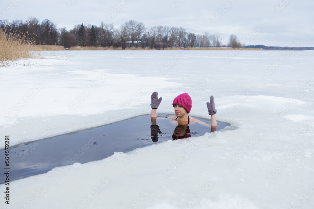 Winter swimming. Woman in frozen lake ice hole. Swimmers wellness and ...